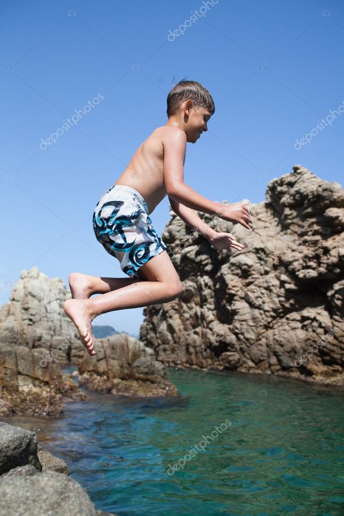 Young boy jumping into the sea — Stock Photo © waldru #32198273