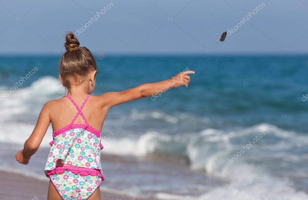 Little girl throws rocks into the sea — Stock Photo © waldru #46300925