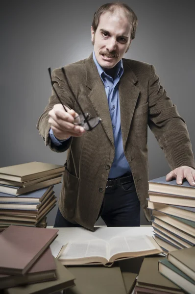 Angry professor rounded with stacks of books Stock Photo by ©Camrocker ...