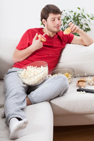 Couch potato eating junk food - Stock Image - Everypixel