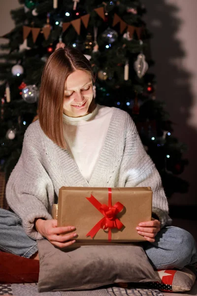 The Magic Of Christmas. Amazed young beautiful woman opening xmas gift ...