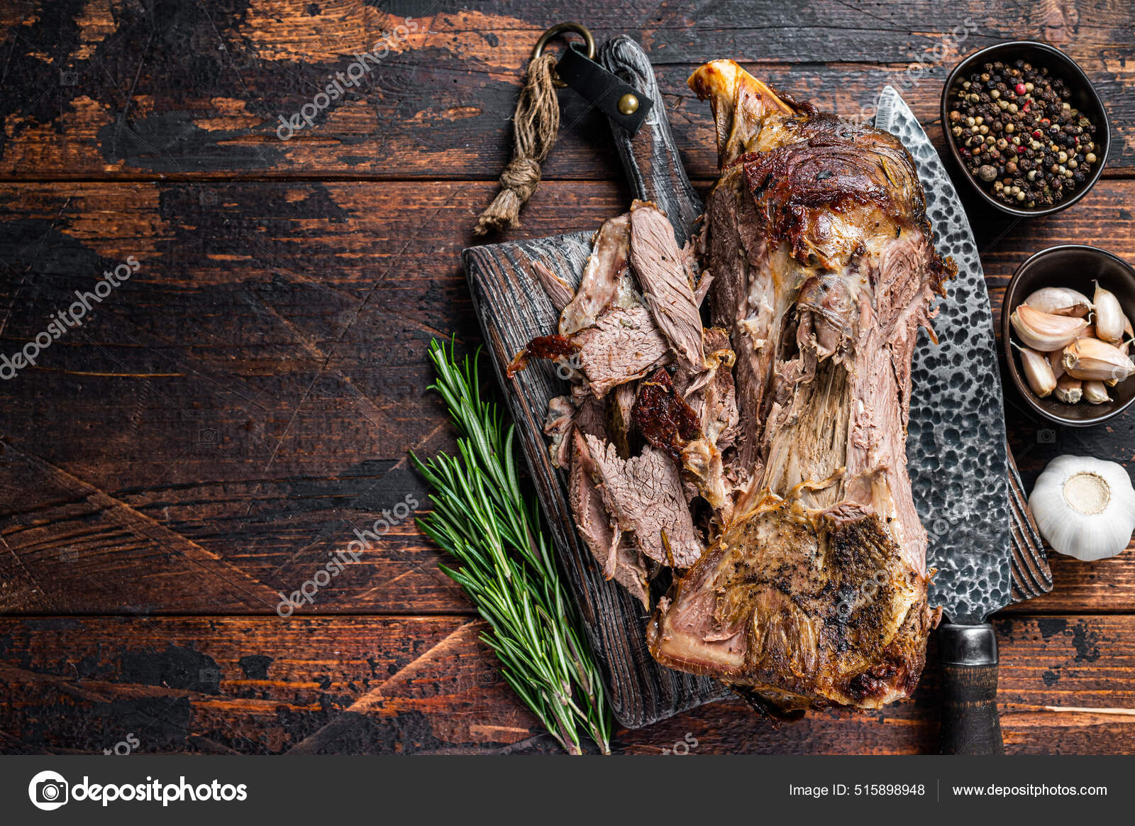 Baked lamb mutton cutting shoulder meat on a wooden board. Dark wooden ...