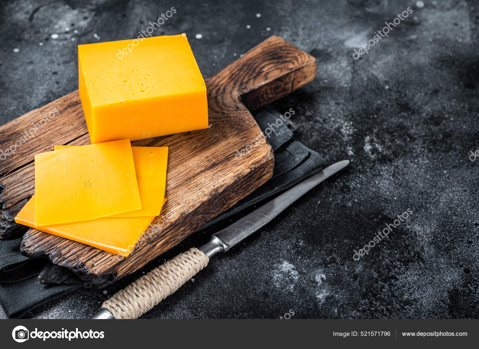 Slices of Cheddar Cheese on a wooden cutting board. black background ...