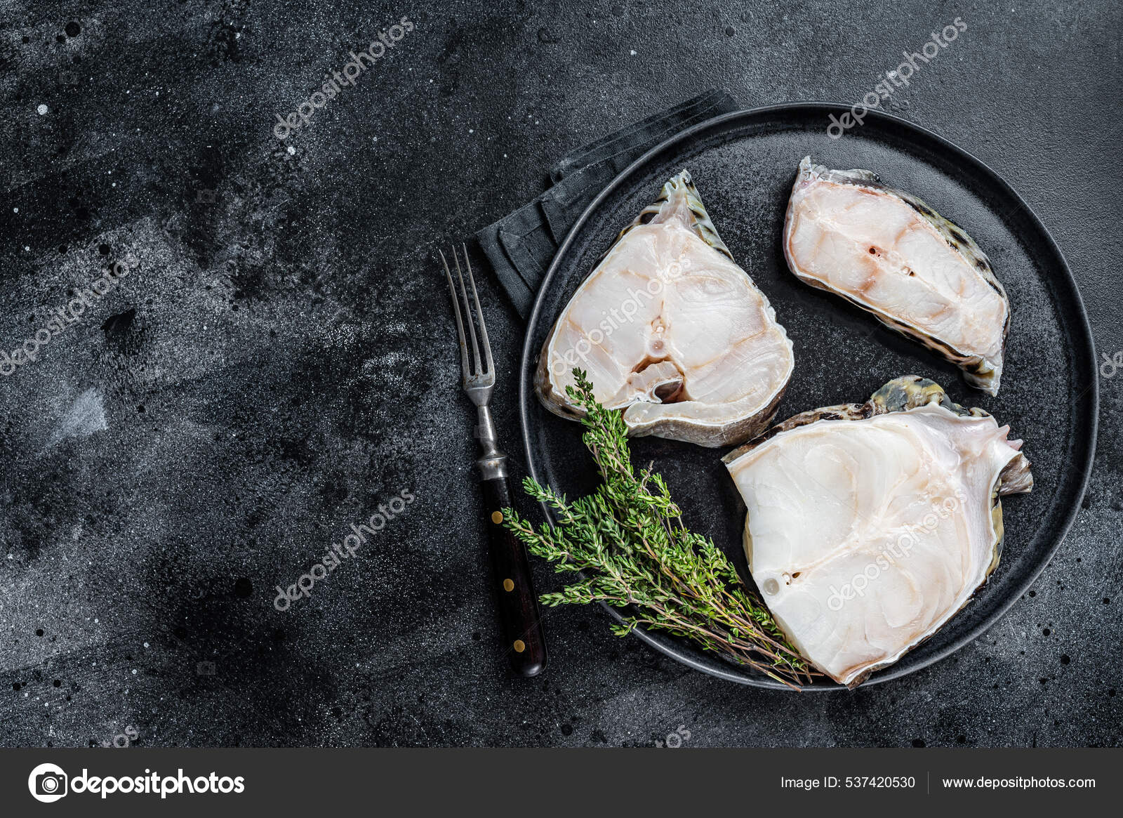 Fresh Raw wolffish o wolf fish Steak on a plate. Black background. Top ...
