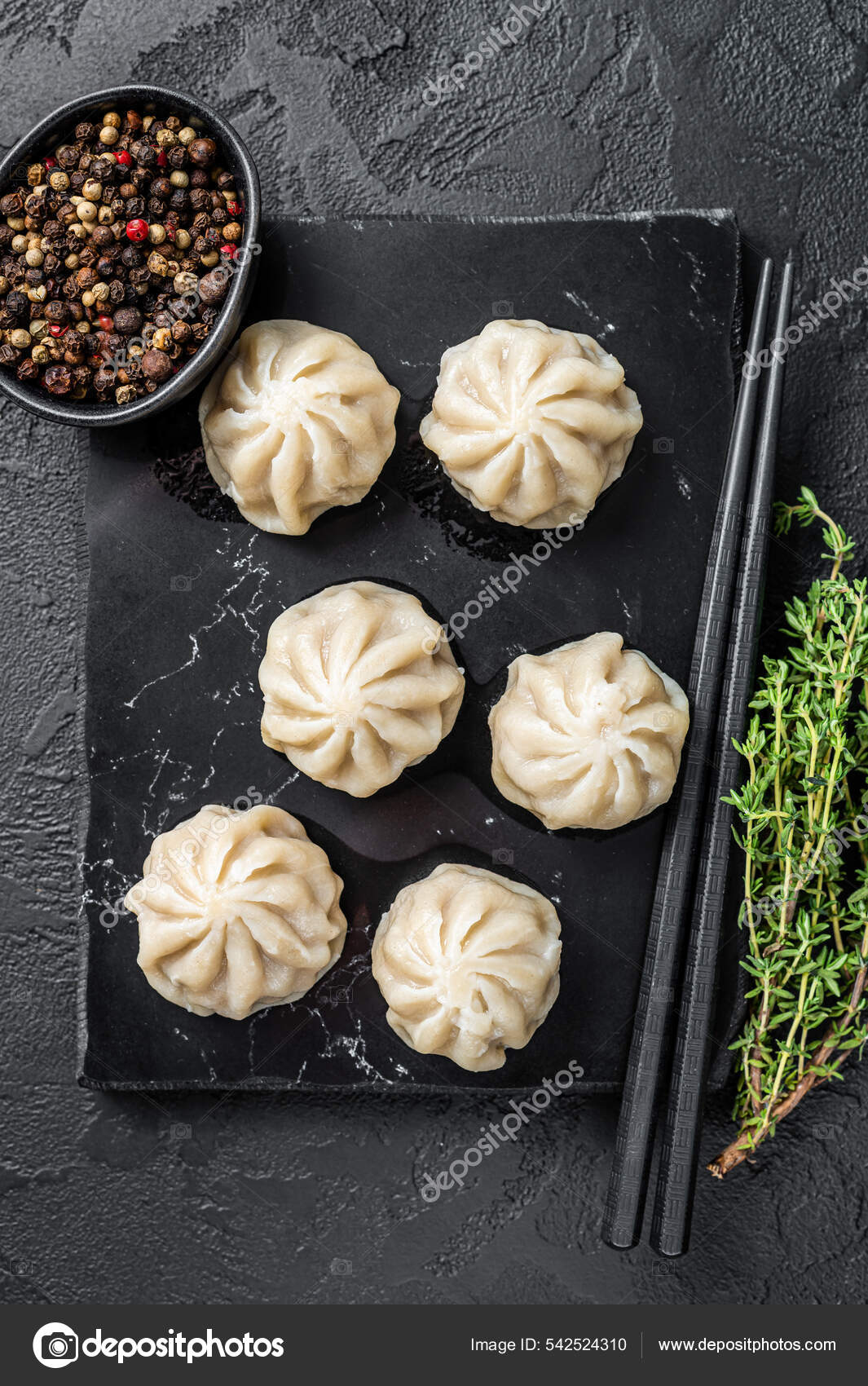 Chinese baozi dumplings on a marble board. Black background. Top view ...
