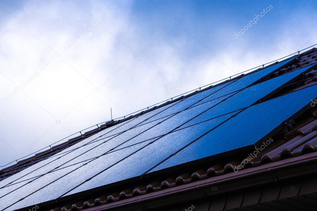 Paneles solares modernos en el techo de una casa en un día lluvioso ...