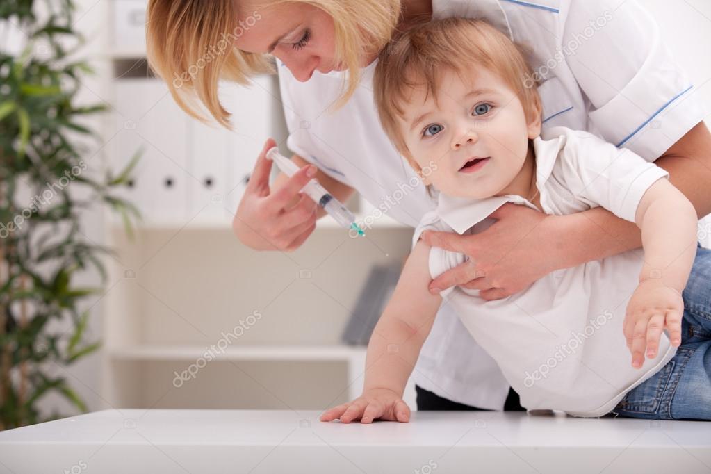 Médico inyectando a un niño en el brazo — Foto de stock #35211093 ...