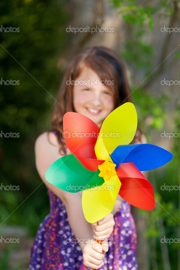 Happy girl presenting windmill Stock Photo by ©racorn 26218113