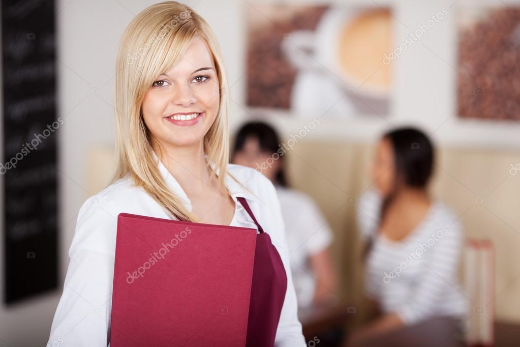 Camarera sonriente celebración de menú en la cafetería — Foto de stock ...