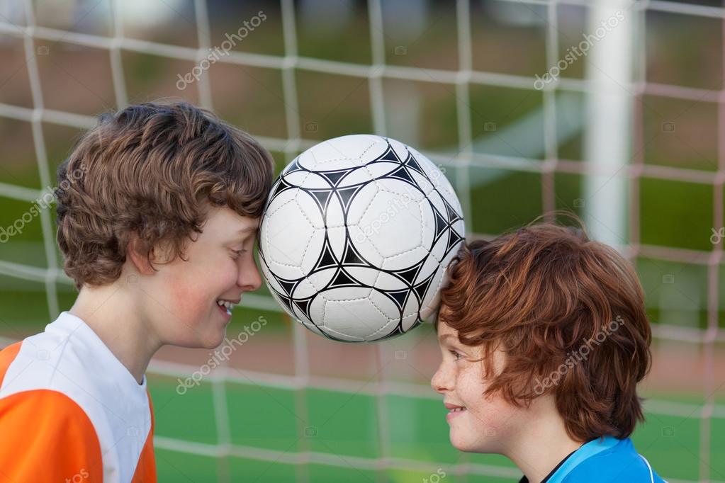 Two friends balancing soccer ball between heads — Stock Photo © racorn ...