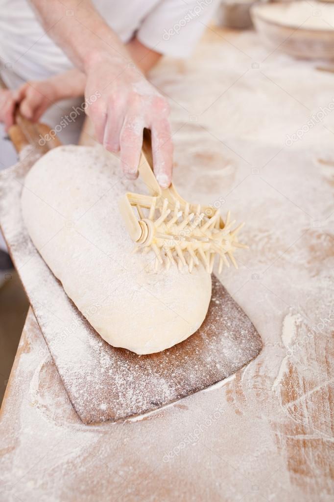 Baker scoring a loaf of bread Stock Photo by ©racorn 27104049