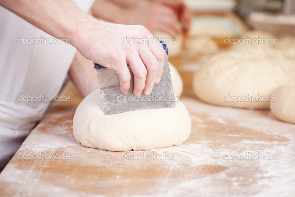 Baker making traditional patterns on bread — Stock Photo © racorn #27104677