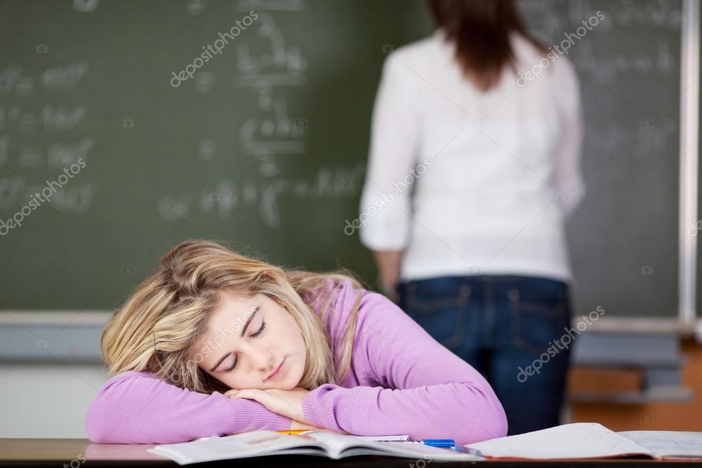 Student Sleeping At Desk With Teacher In Background Stock Photo by ...