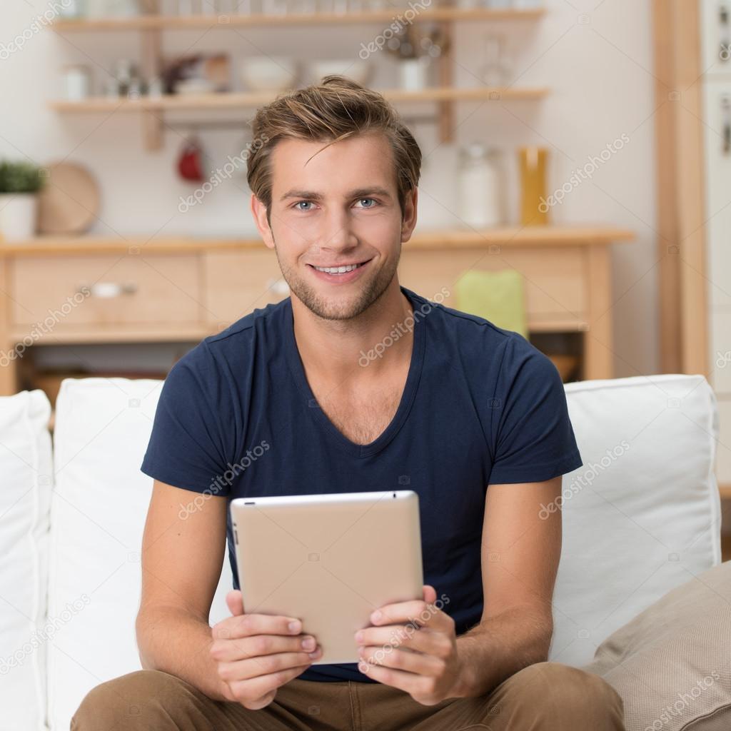 Casual young man holding a tablet-pc — Stock Photo © racorn #31316631 Casual young man holding a tablet-pc — Stock Photo © racorn #31316631