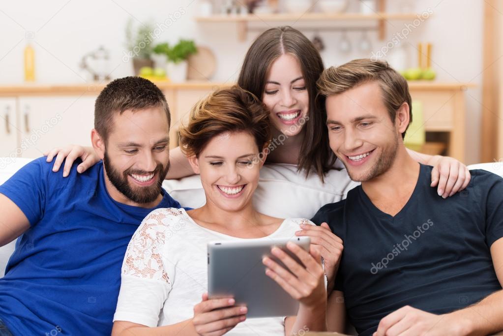 Group of happy friends sharing a tablet — Stock Photo © racorn #31828505