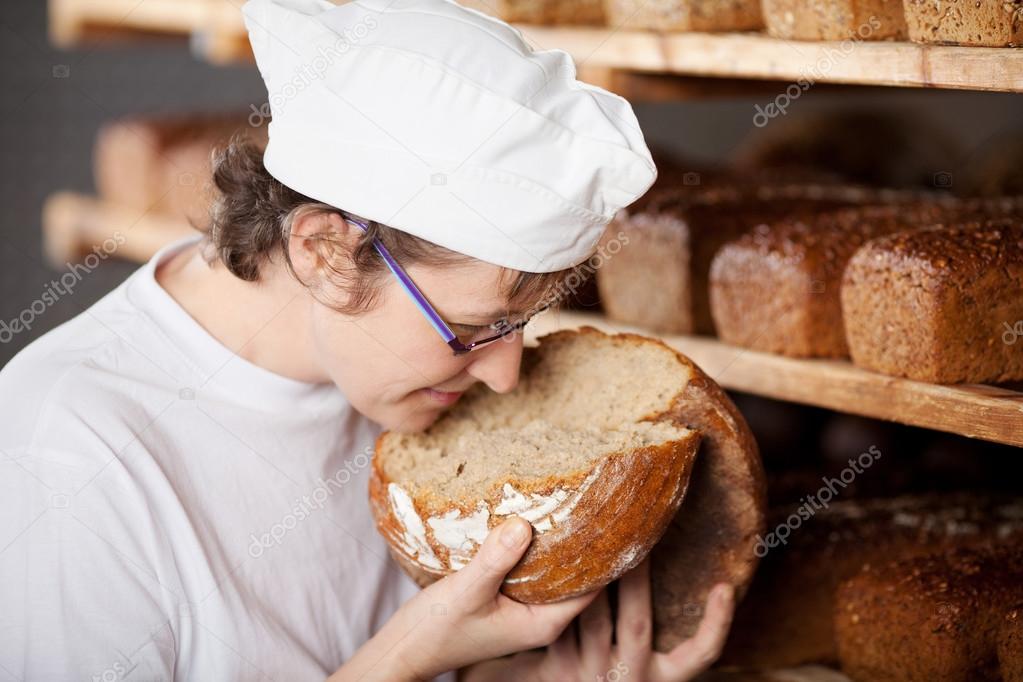 Female bakery worker smelling bread Stock Photo by ©racorn 50584575