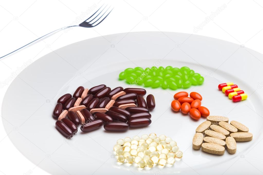 Plate with food supplements pills Stock Photo by ©apetrenko 26001157