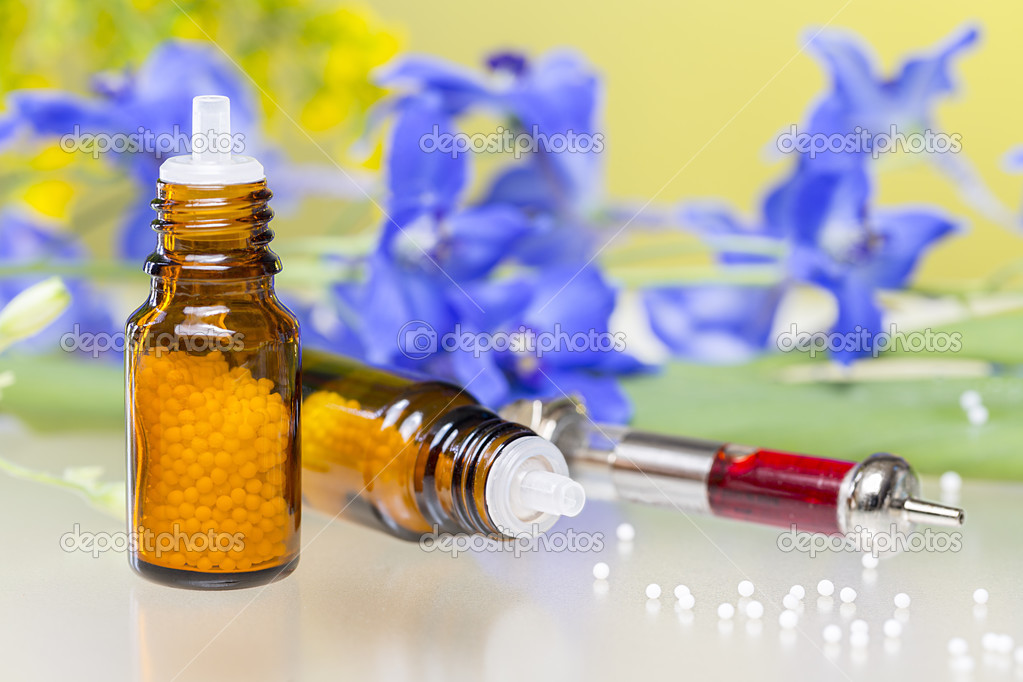dos frascos con glóbulos homeopáticos, flores y jeringa con b 2023