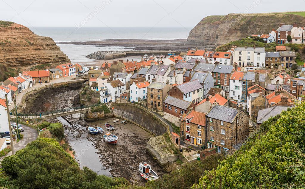 Casas agrupadas en Staithes mientras el Roxby Beck serpentea a través ...