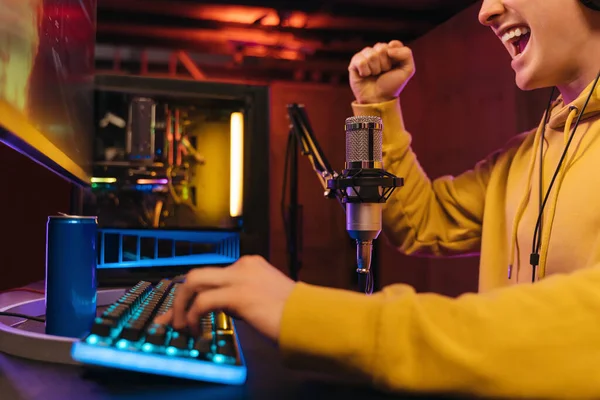 Pro gamer wearing headphones celebrating his winning in online esport ...