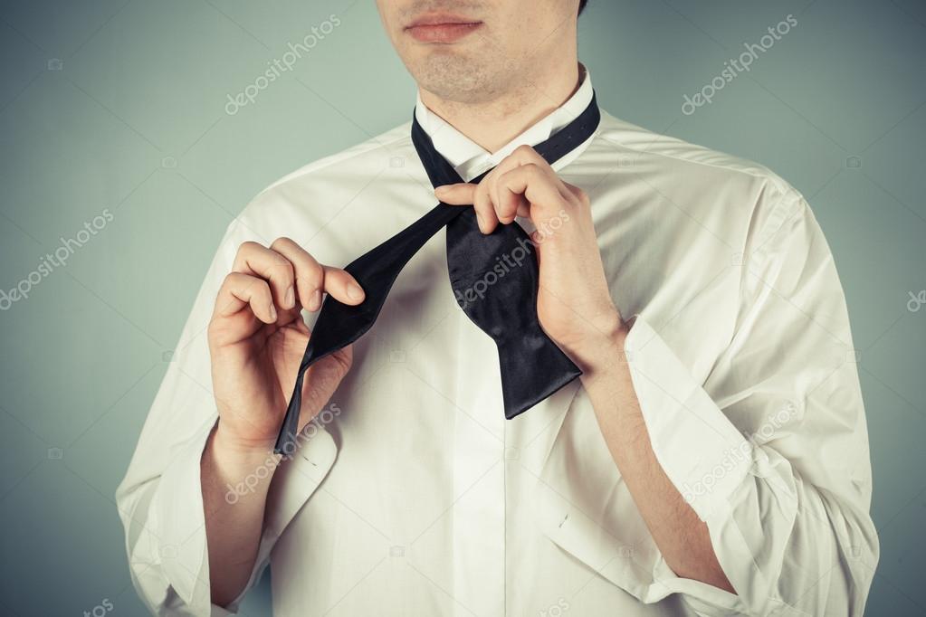 Young man tying a bow tie Stock Photo by ©lofilolo 43830895