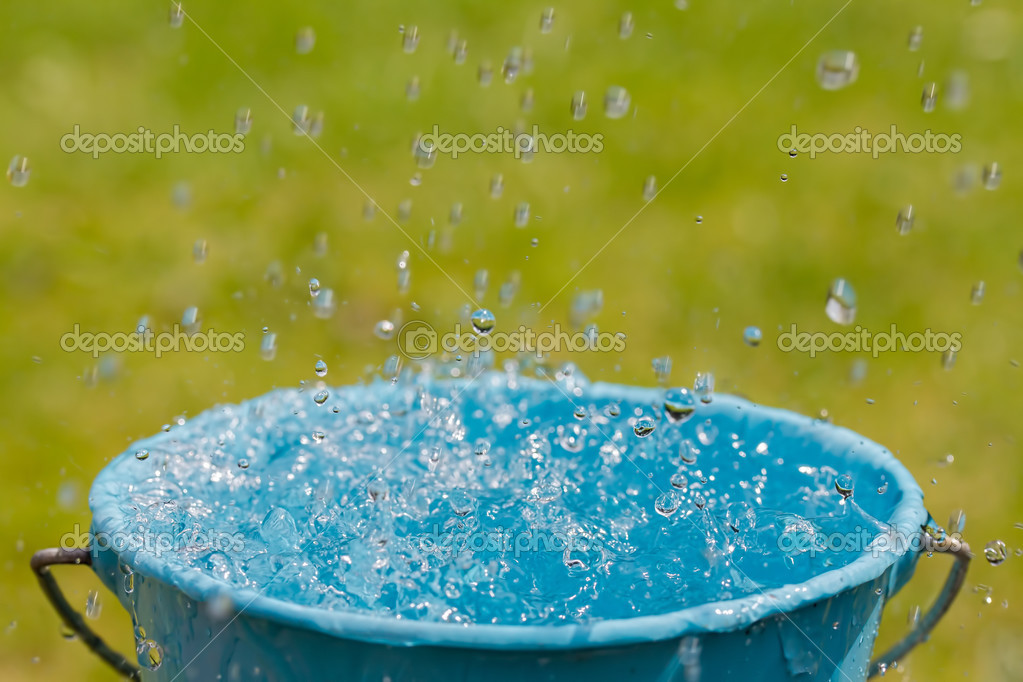 Rain falling into full bucket of water — Stock Photo © sc-images #49951209