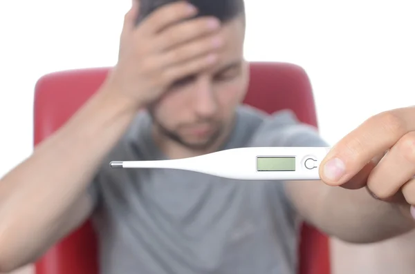 Young man taking temperature - Stock Image - Everypixel