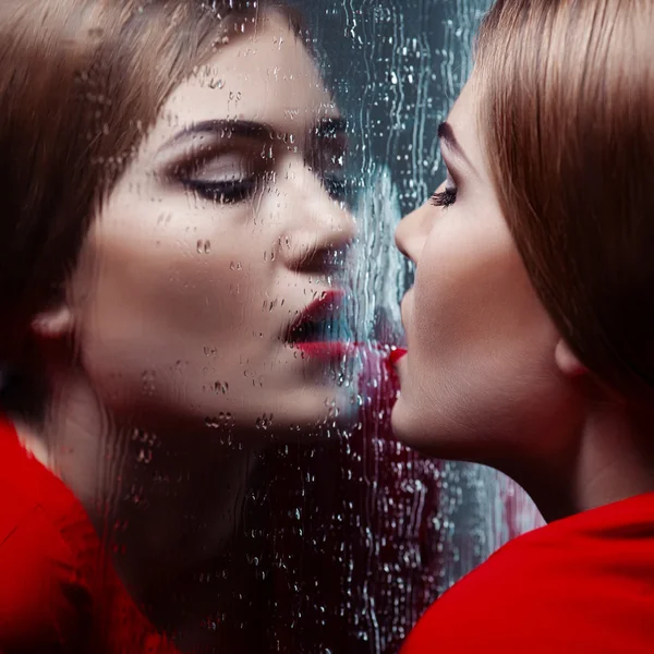 Beautiful Sexy Girl In Red With Bright Makeup Looks In The Mirror Stock