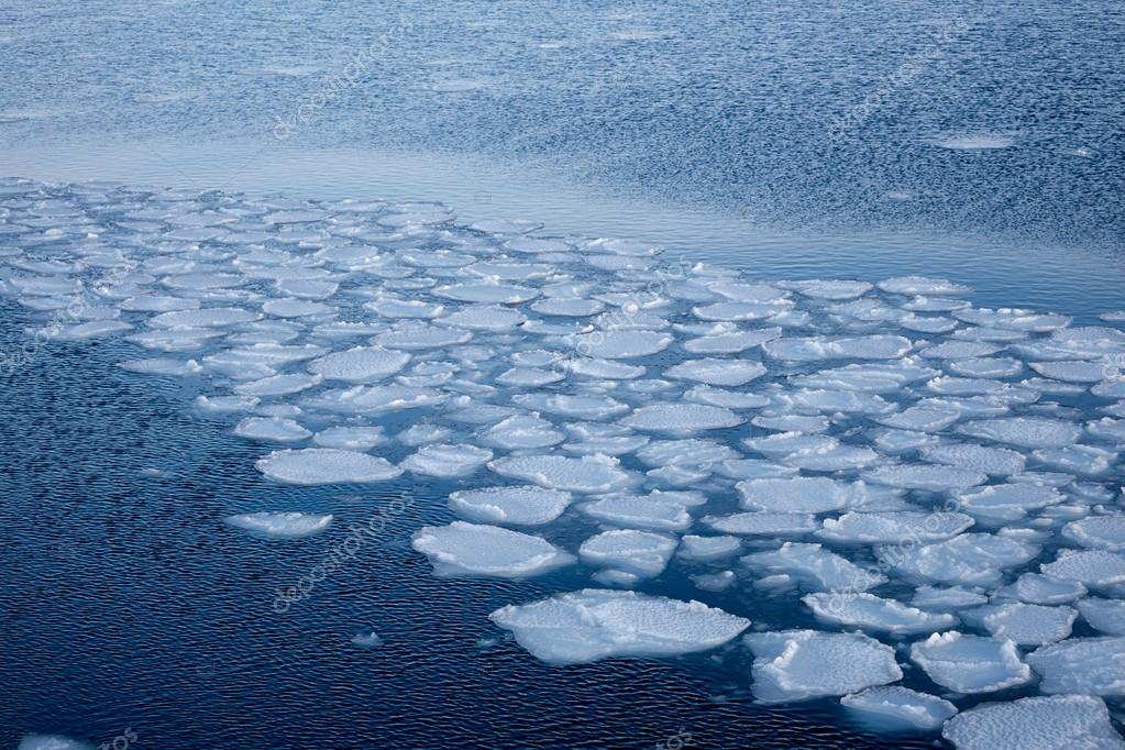 Natural ice blocks breaking up against shore and sea ice during — Stock ...