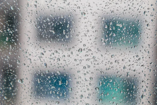 Rain drop on window close up weather sign on condominium block ...