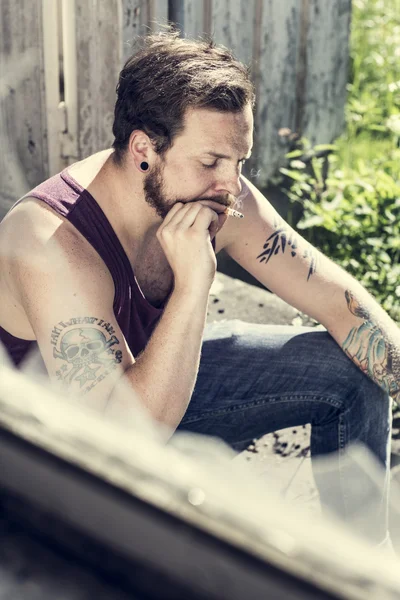 Thinking rocker sitting on staircase and smokes — Stock Photo © kjekol ...