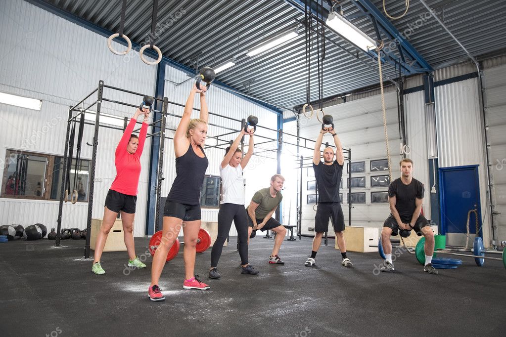 Team workout with kettlebells at fitness gym — Stock Photo © kjekol ...
