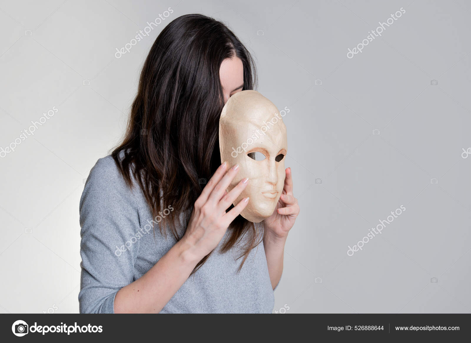 Complexes because of appearance. A young woman hides her face behind a ...