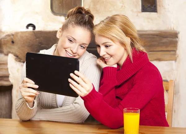 Two beautiful women work on the tablet - Stock Image - Everypixel
