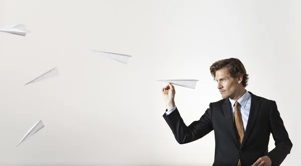 Businessman throwing paper airplanes at target - Stock Image - Everypixel