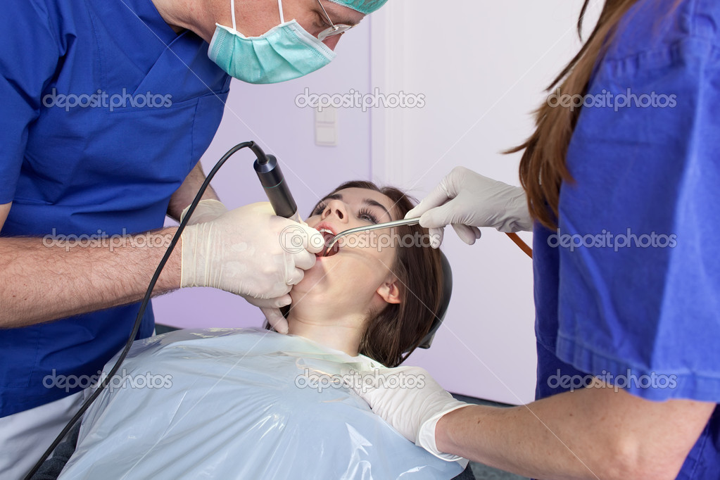 Dentista y su asistente operando a un paciente. 2023