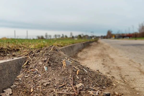 City cleaning service clean asphalt road.Pile of dust, sand on roadside ...