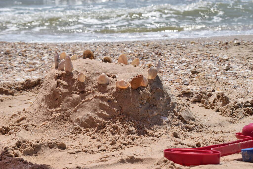 Castillo de arena con conchas construido en la playa tropical de verano ...