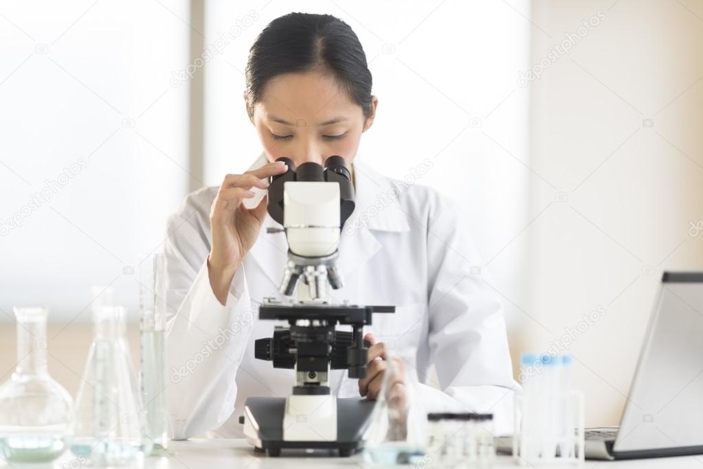 Doctor Using Microscope At Desk In Laboratory Stock Photo by ©tmcphotos ...