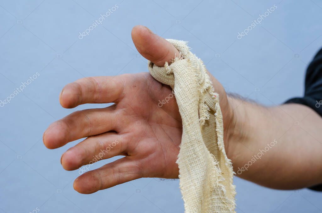 La mano del hombre con una estrecha tira de tela. Mano derecha con ...