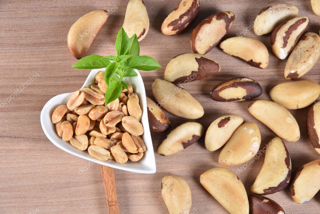 Brazil nuts on the table with a pot of peanuts on the side, typical ...