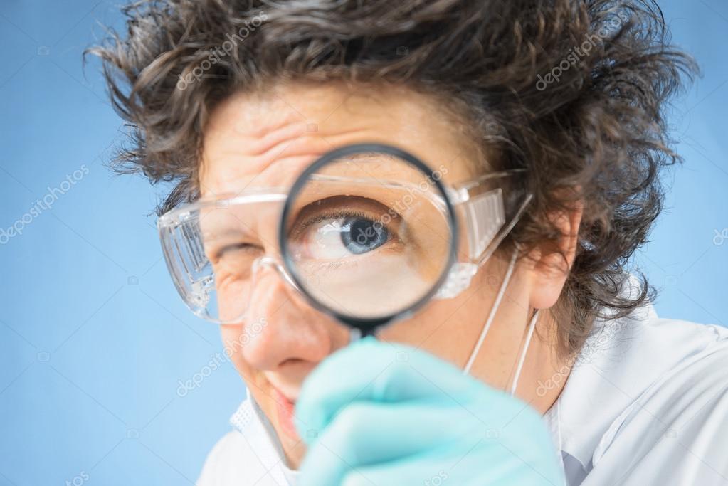 Scientist looks through a magnifying glass — Stock Photo © Remains ...