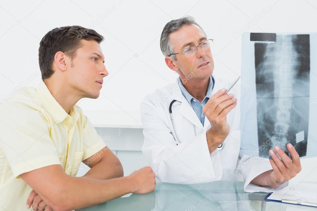 Doctor explicando la radiografía pulmonar al paciente en el consultorio ...