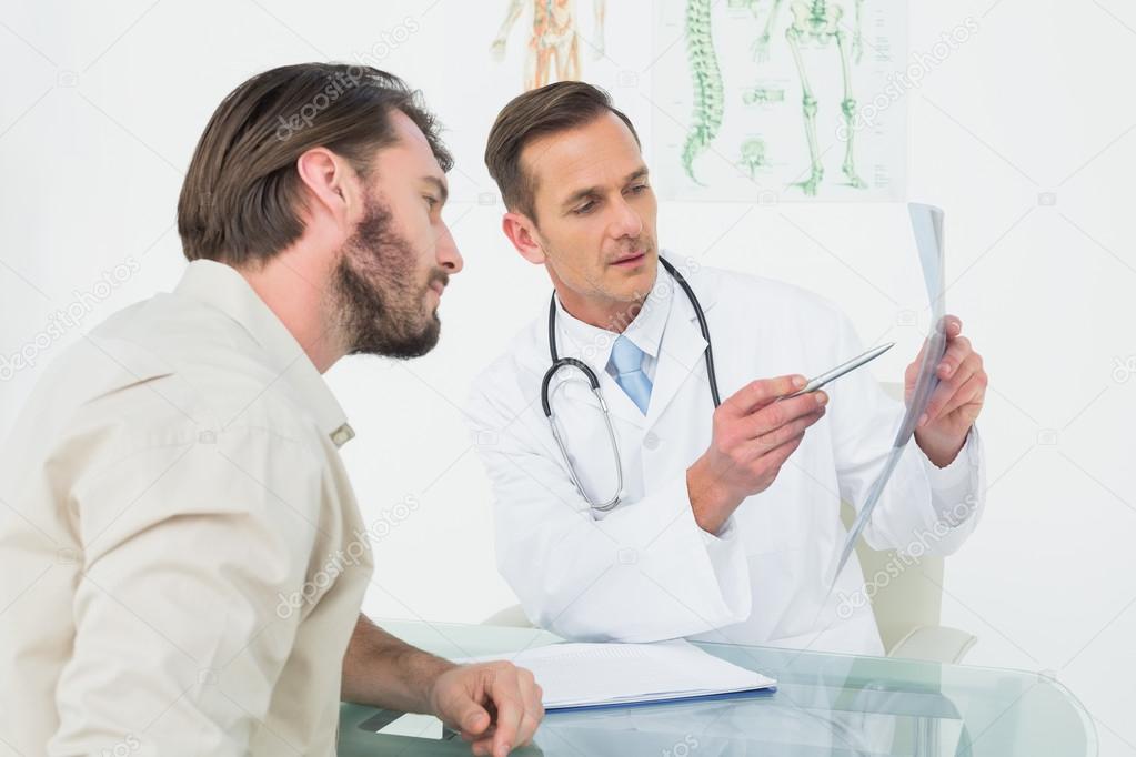 Male doctor explaining spine x-ray to patient — Stock Photo ...