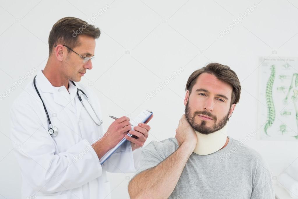 Male doctor examining a patient's sprained neck Stock Photo by ...