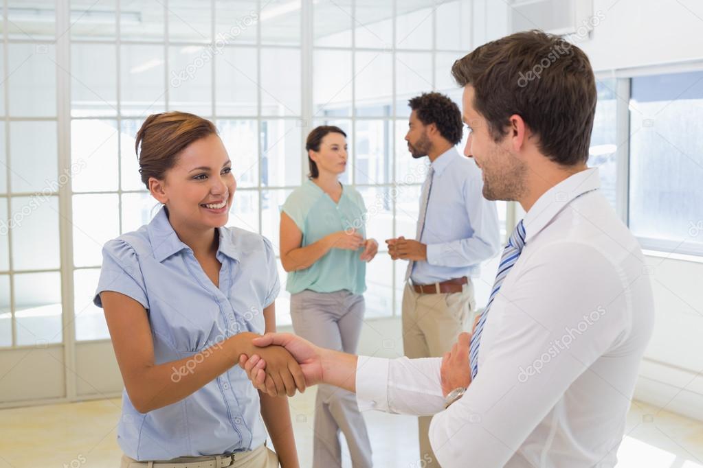 Business people shaking hands with colleagues in office — Stock Photo ...