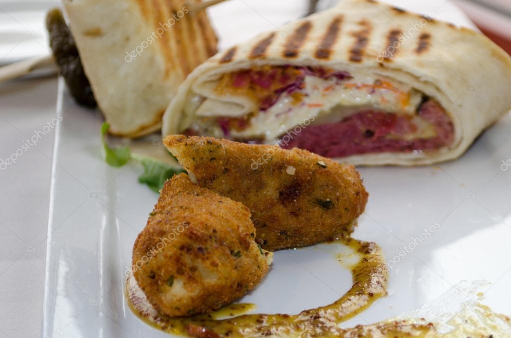 Corned beef and swiss wrap with potato crouquette Stock Photo by ...