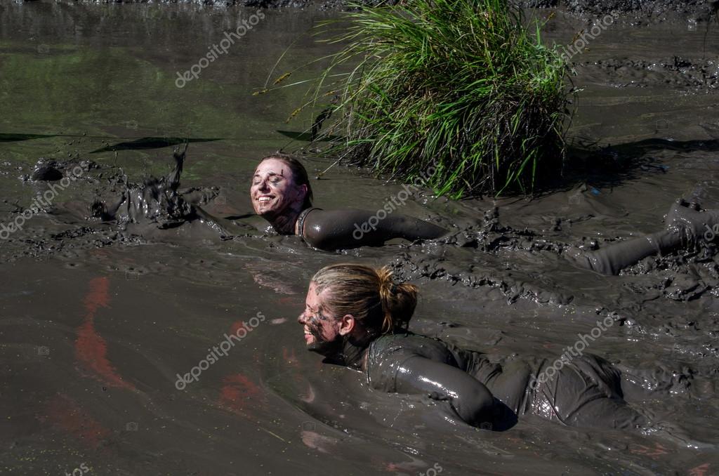 Two women enjoy the mud during a mudathalon race – Stock Editorial ...