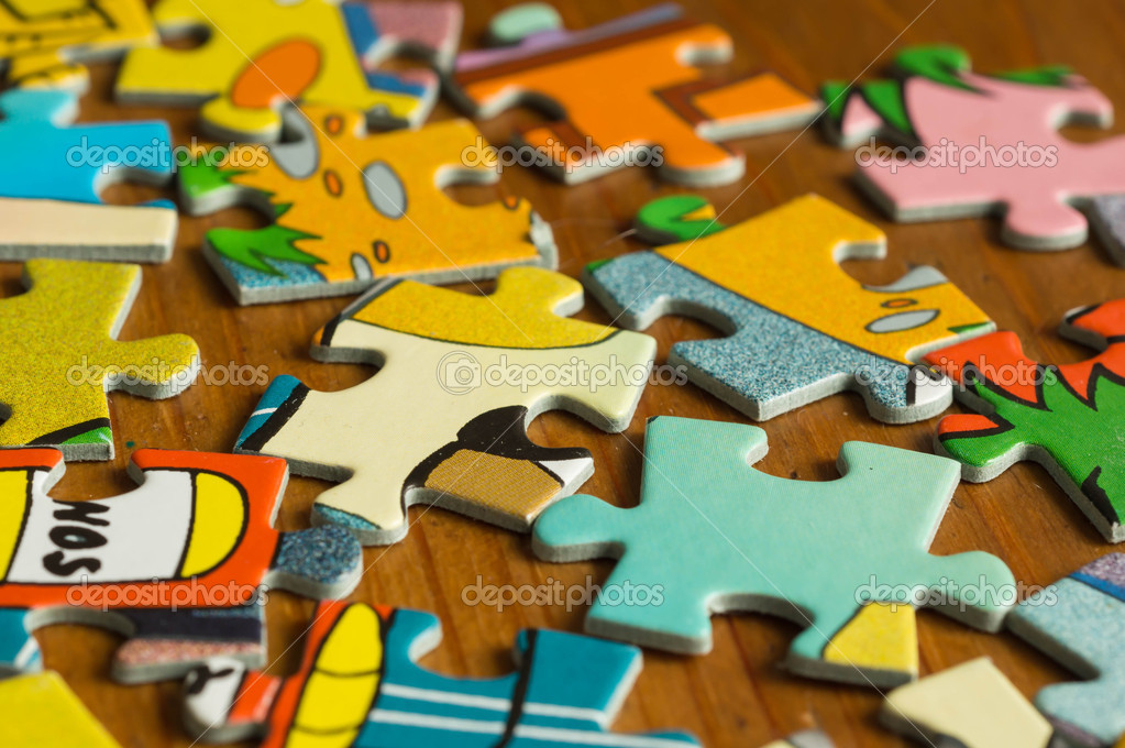 Barn pussel utspridda på ett träbord — Stockfotografi © Tallula #37826847