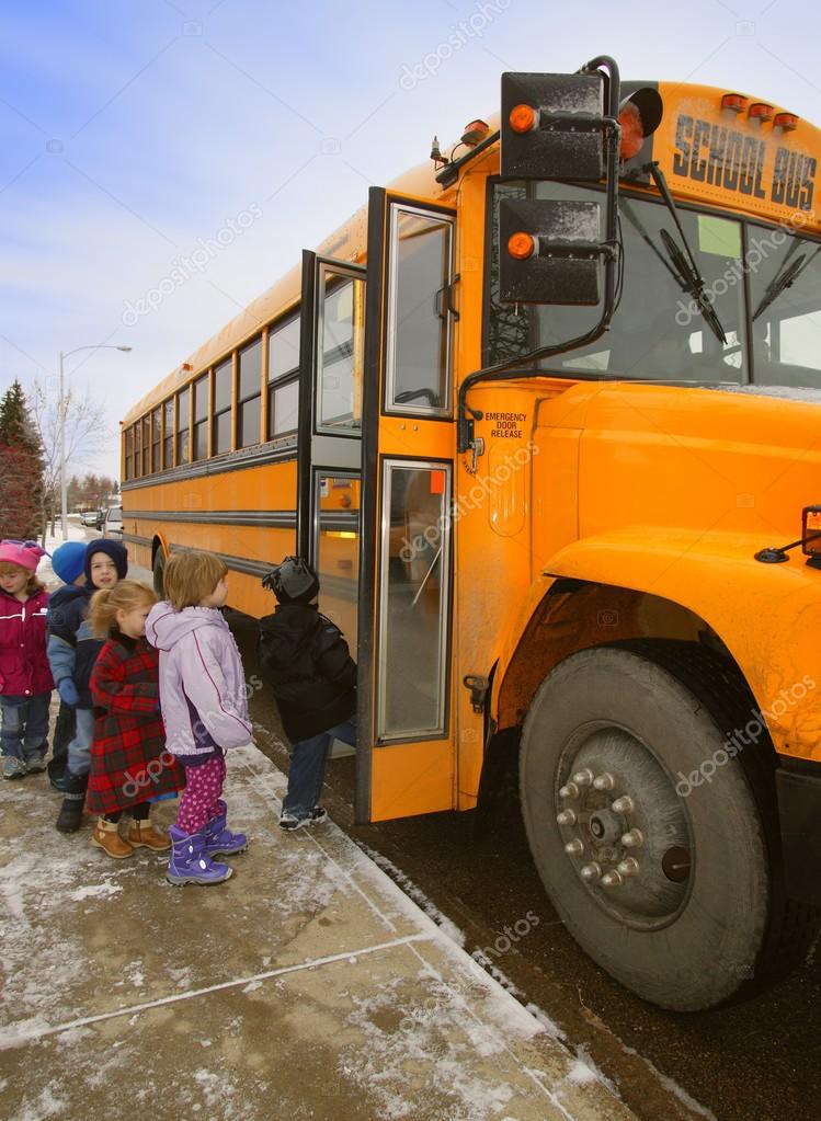Elementary Schoolchildren Boarding School Bus On A Cold Winter Day In ...
